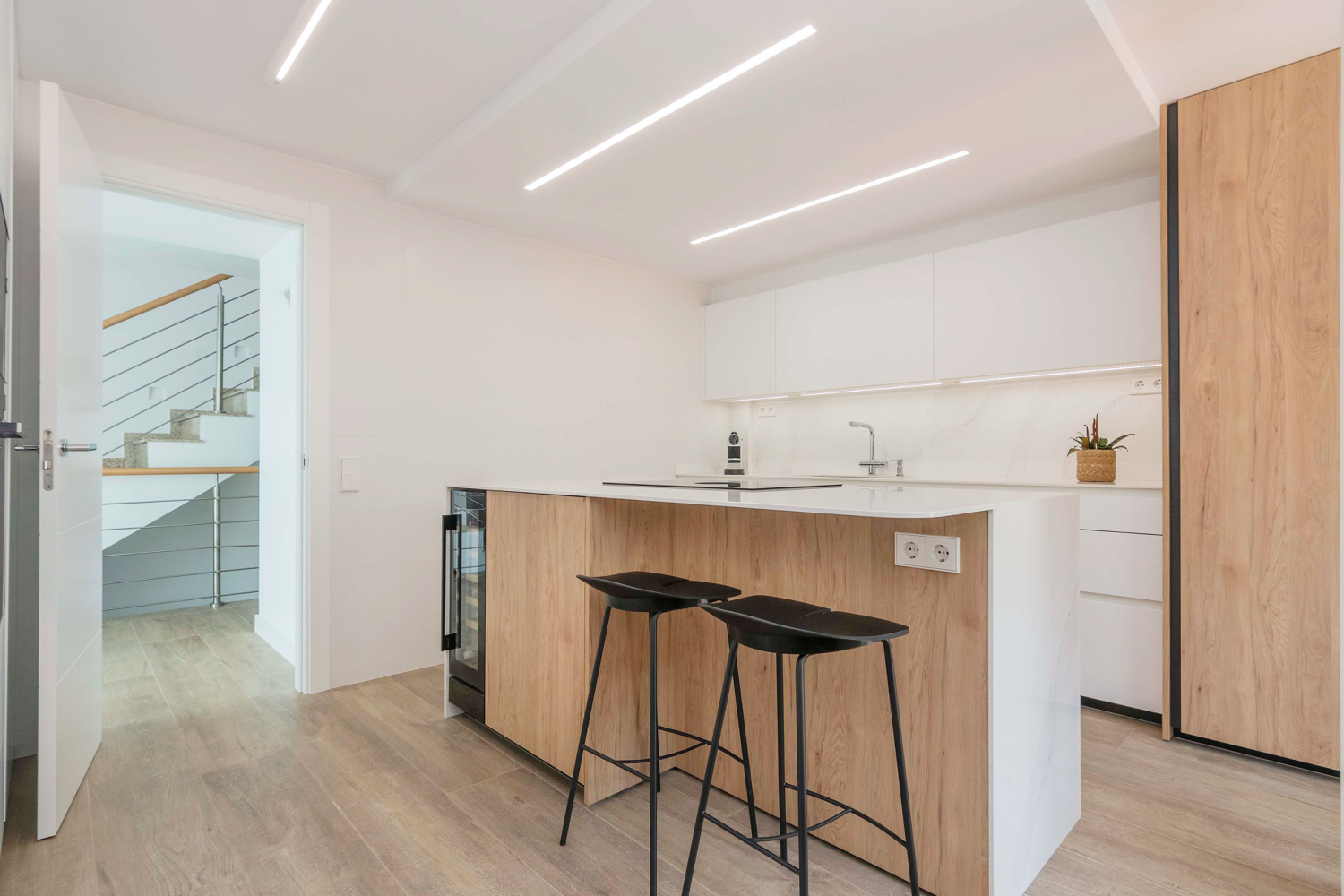 Saitra y Vibel Estudi dan forma a una cocina en blanco y madera con luz ...